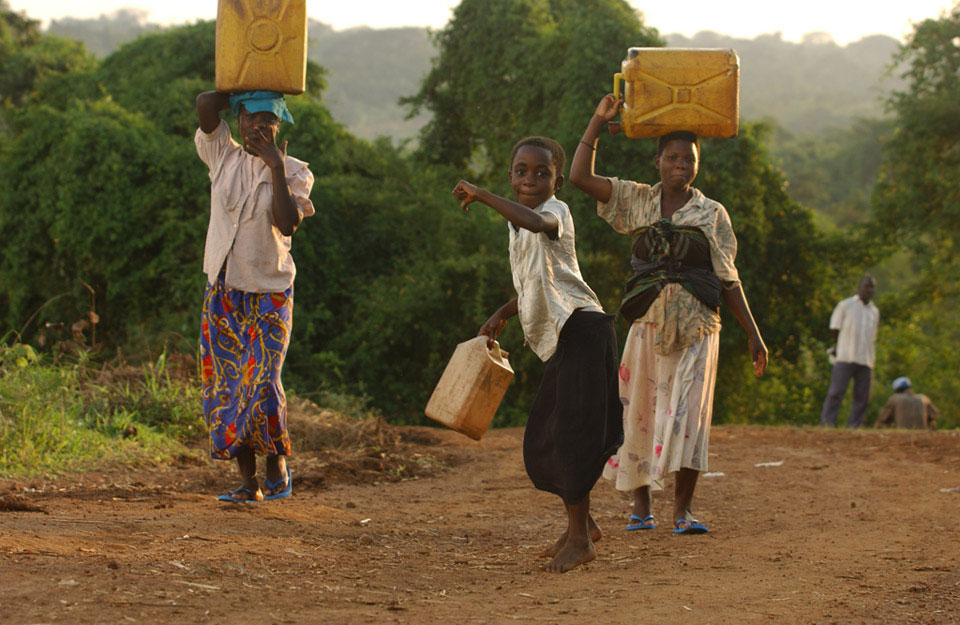 Villagers walking with water containers in Kamuli district of Uganda ...