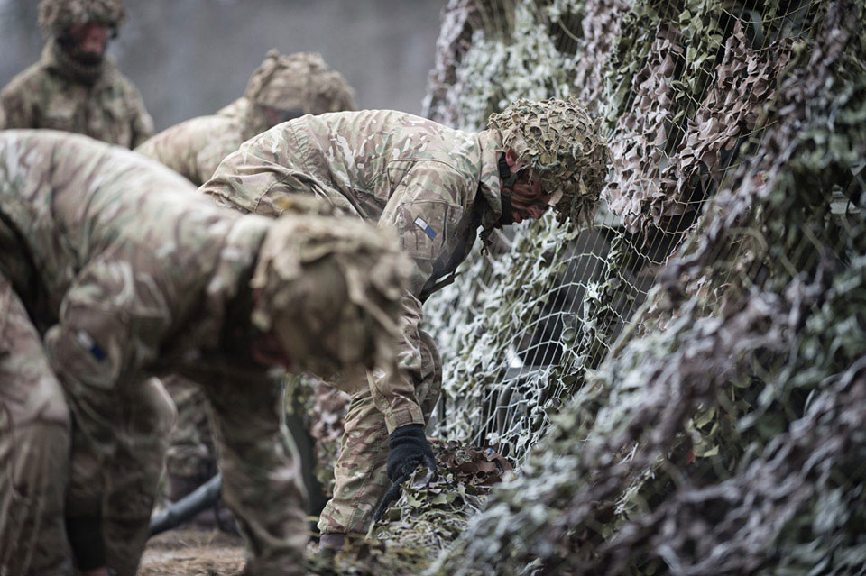 Soldiers of the Royal Signals roll up camouflage netting to uncover ...